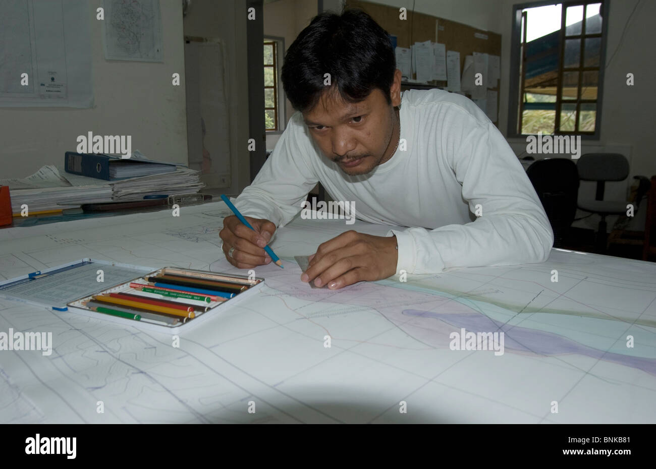 Filipino geologist plots the drilling sites at a copper mine in ...