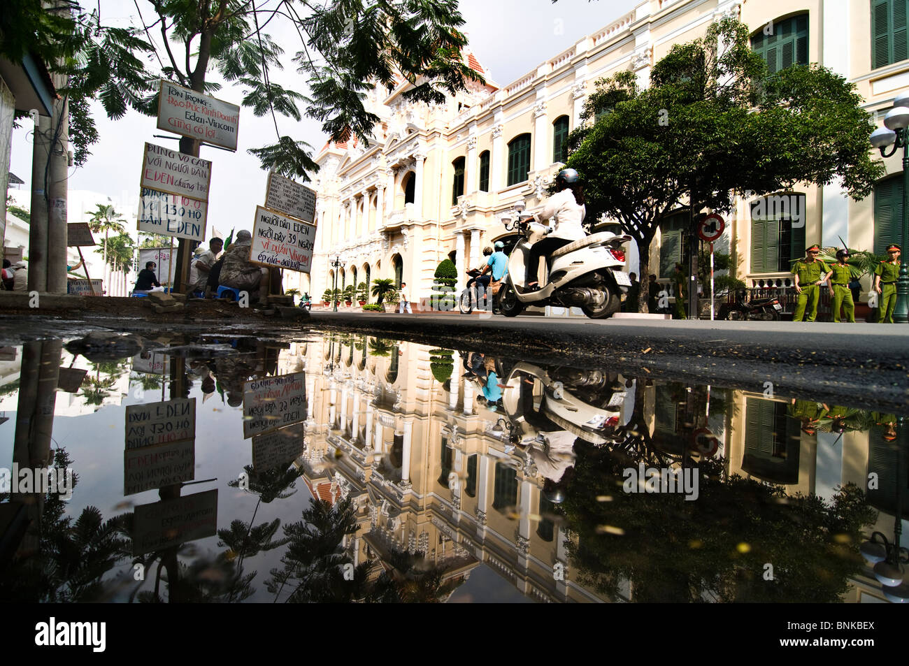Saigon city municipality building reflected in puddle created by the ...