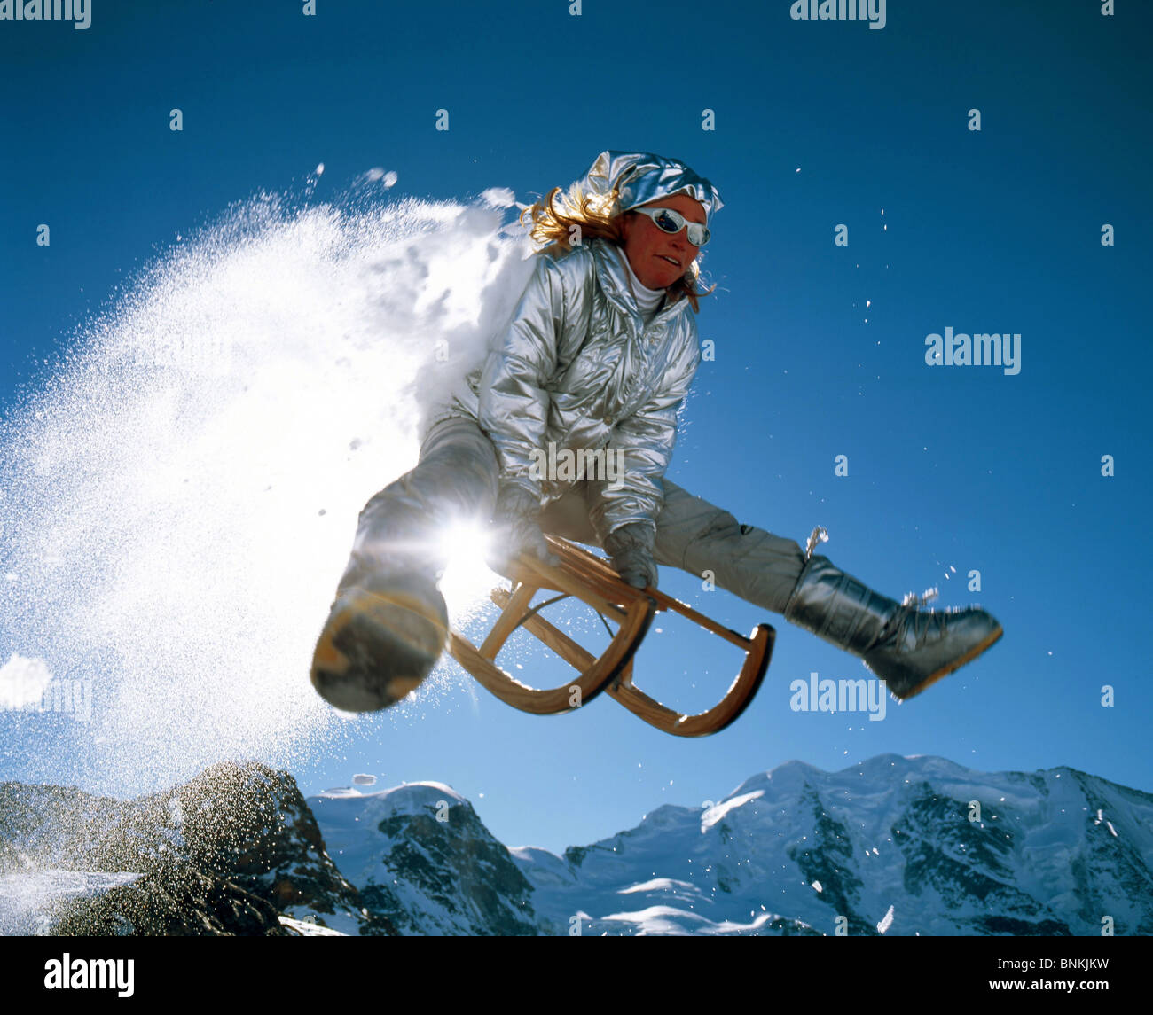 Switzerland winter sports sledge sleigh jump caper mountains sun back ...