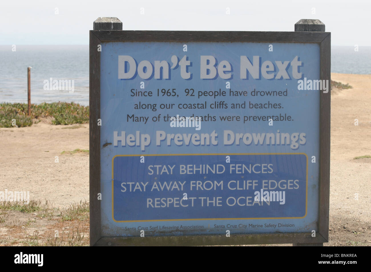 A sign warning people to stay away from cliff edges near surfing area ...