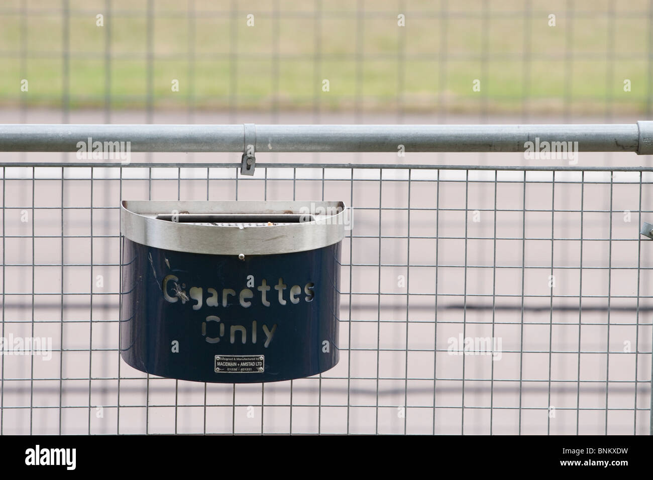 Cigarette bins mounted on a fence Stock Photo - Alamy