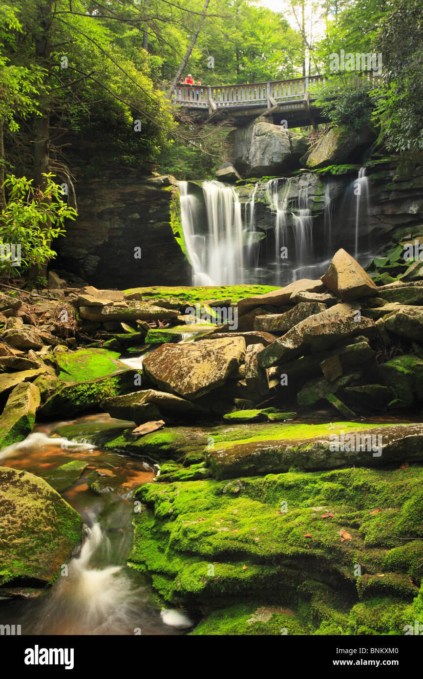 A hiker pauses on the bridge over Elakala Falls in Blackwater Falls ...