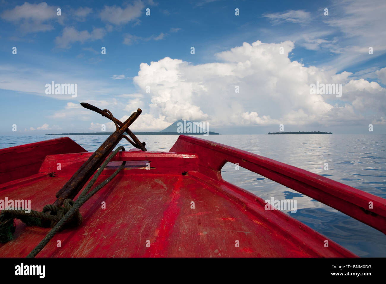 Pulau Manado Tua with clouds as seen from the bright red bow of a dive ...