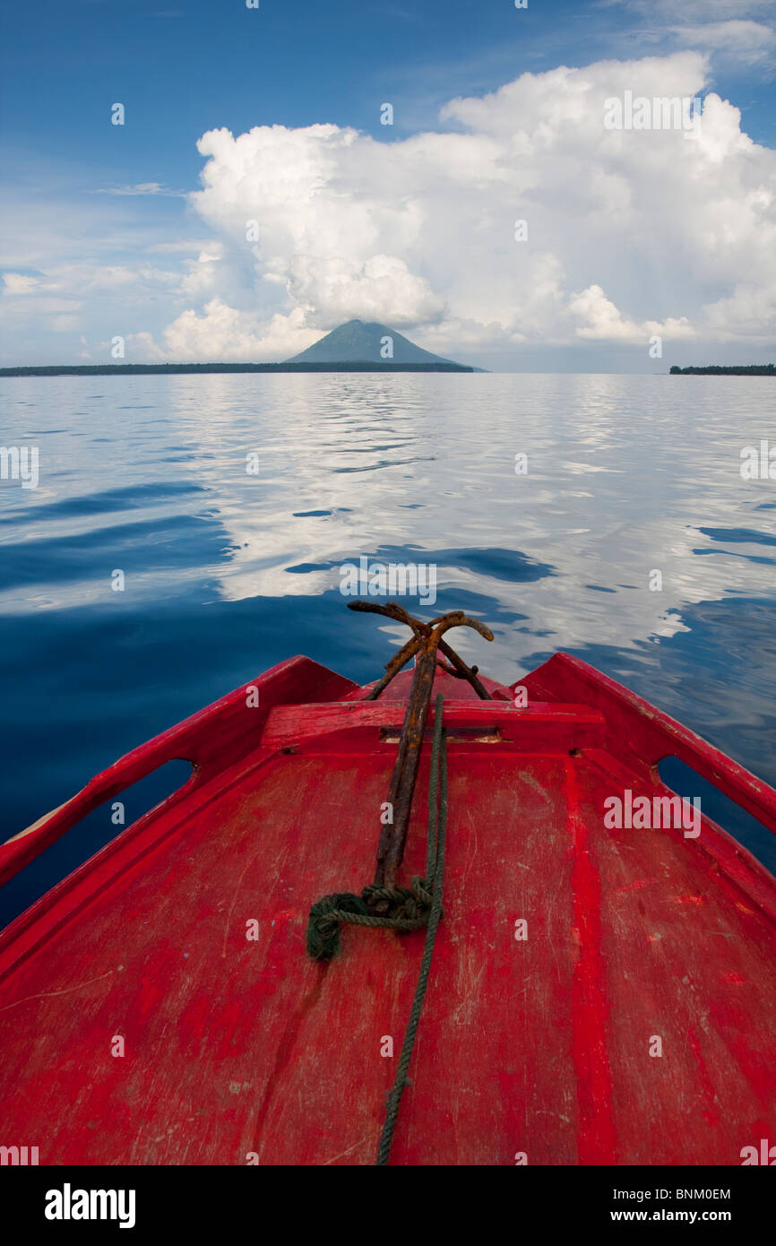 Pulau Manado Tua with clouds as seen from the bright red bow of a dive ...