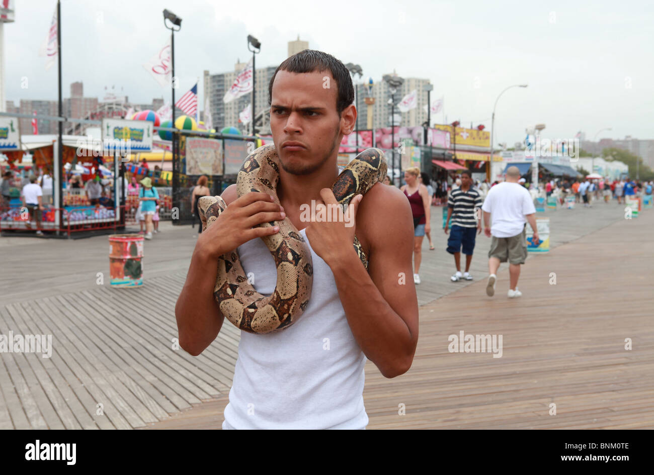 Angry man hold snake on his shoulders on the boardwalk at Coney Island ...