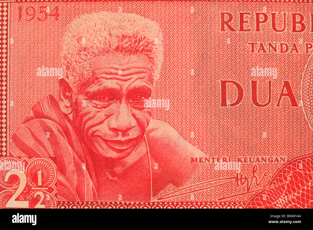 Vintage Indonesian Currency bank note close up of an old man, all red ...