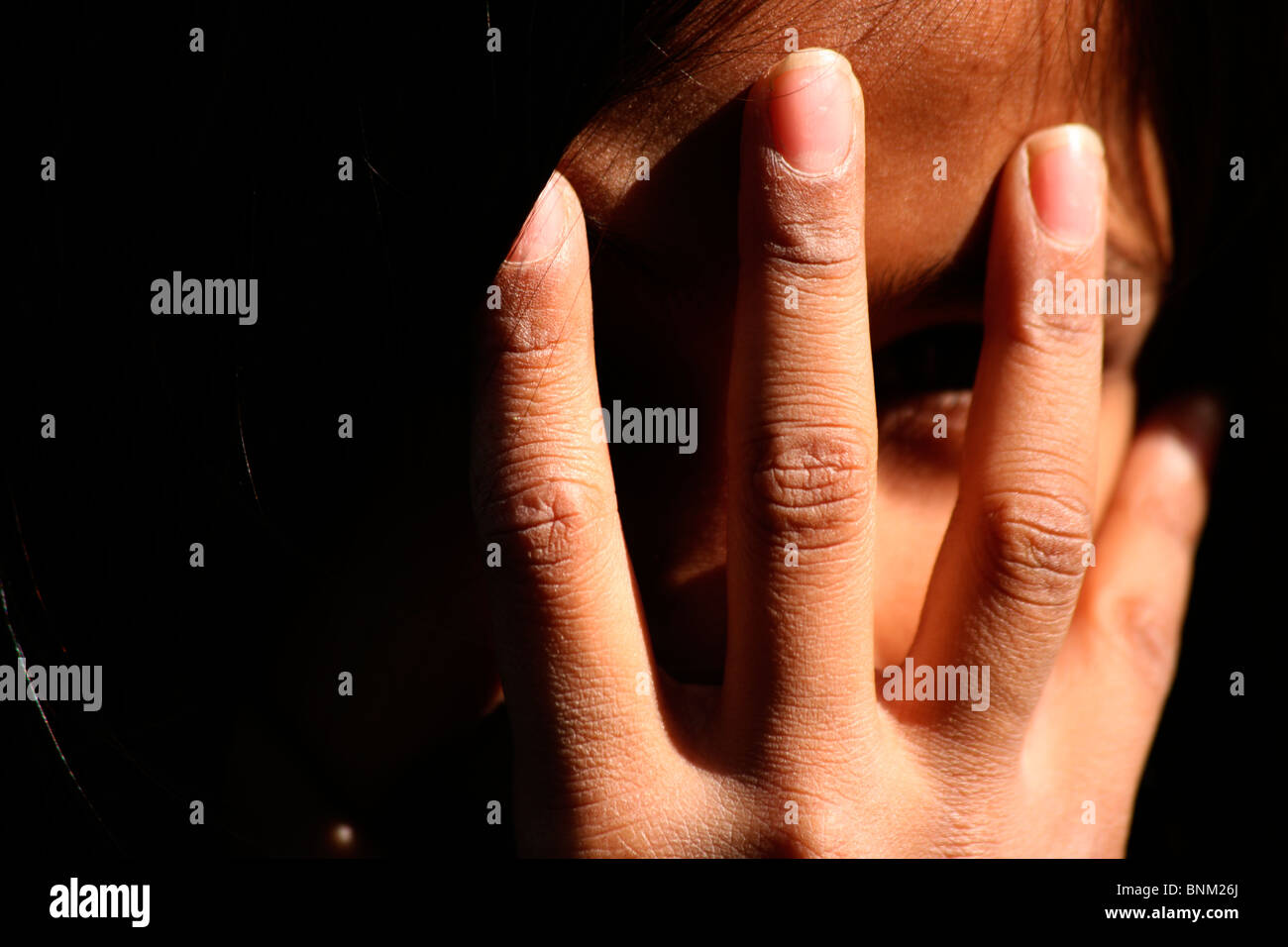 An indian girl hiding her face with her fingers Stock Photo - Alamy