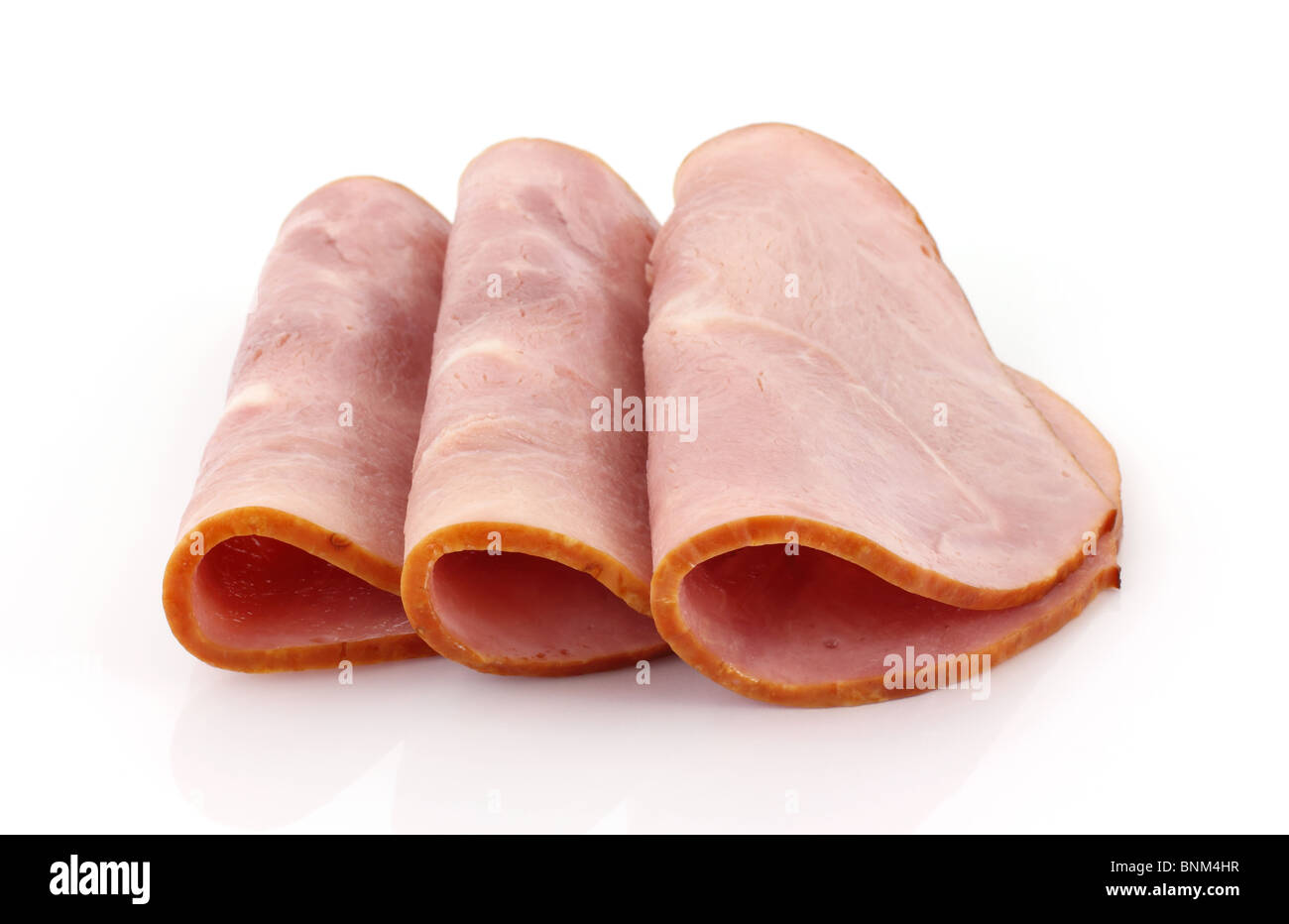Three slices of baked ham folded in half Stock Photo - Alamy