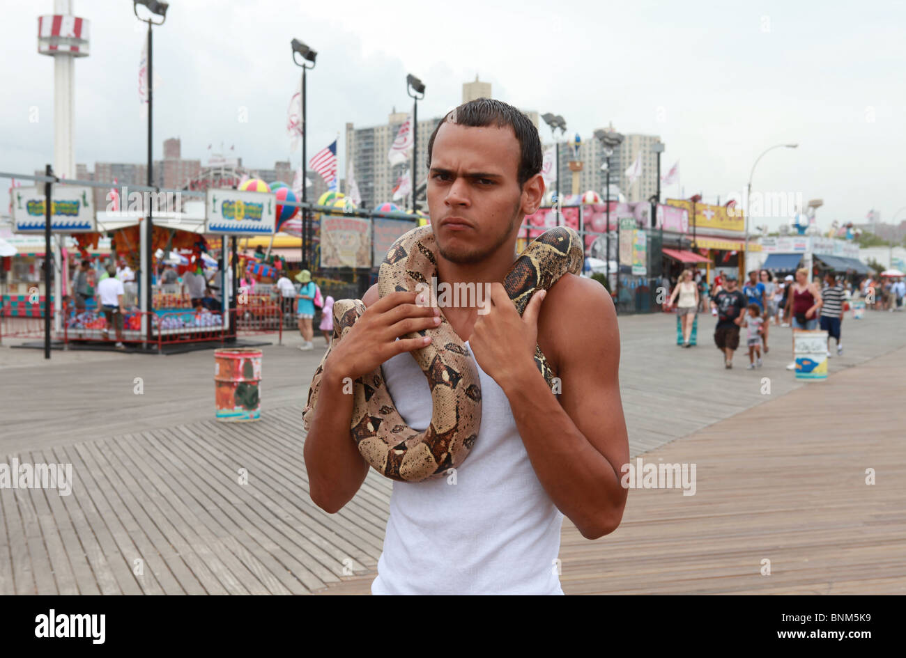 Angry man hold snake on his shoulders on the boardwalk at Coney Island ...