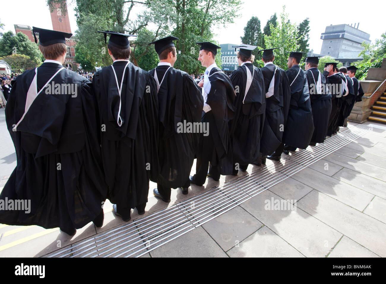 Male graduates line up to have their picture taken after their ...