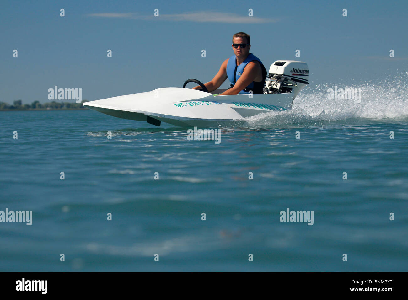 A young man driving a small, home-made hydroplane boat Stock Photo - Alamy