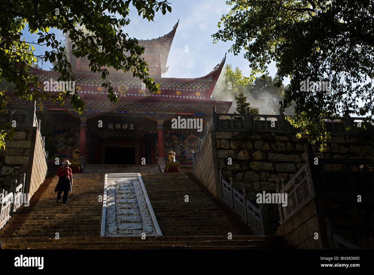 A Tibetan man walking down the steps of a Buddha temple in China Stock ...