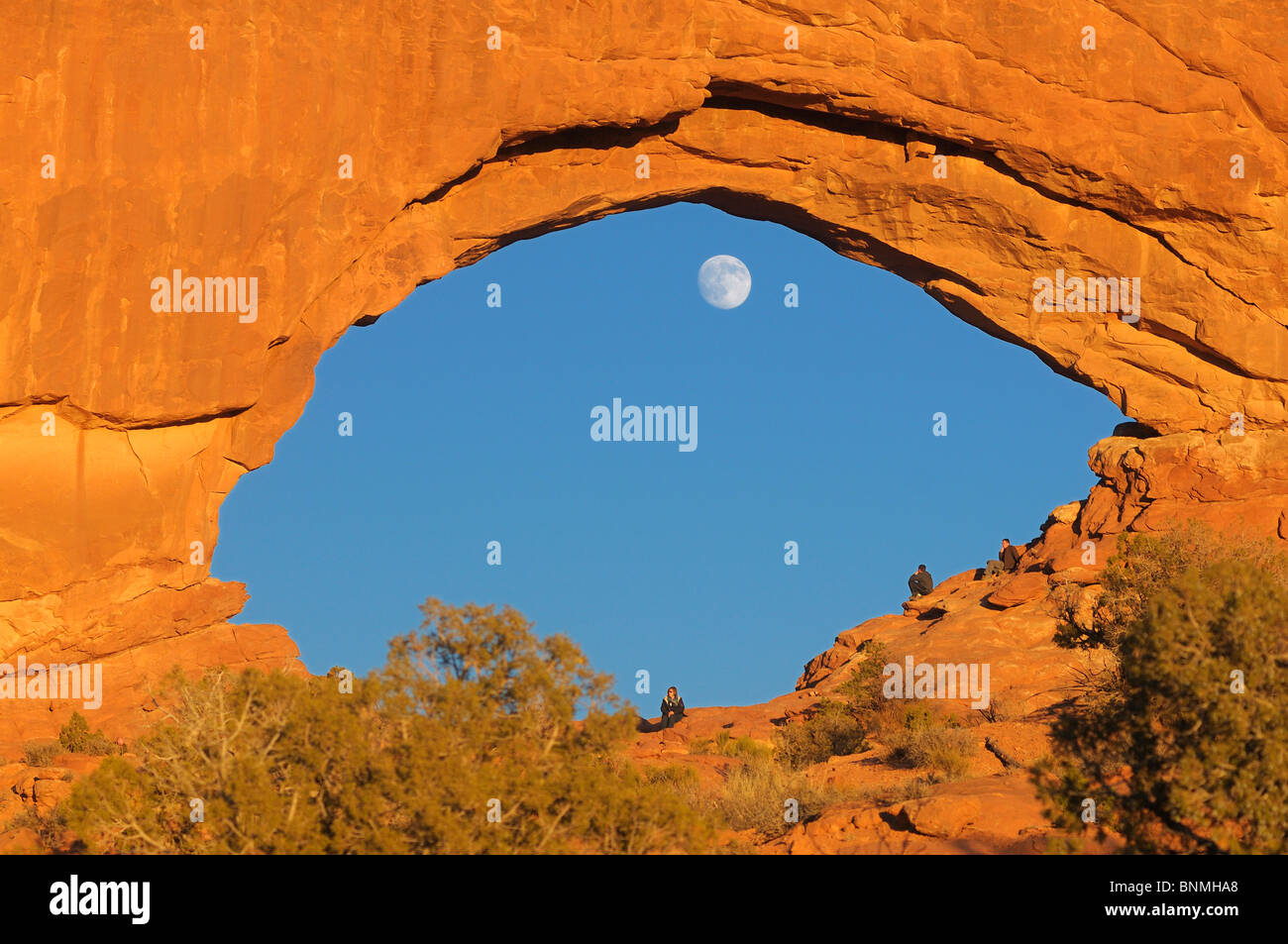 Arch Windows Section Red Rocks sunlight moon persons sitting blue sky ...