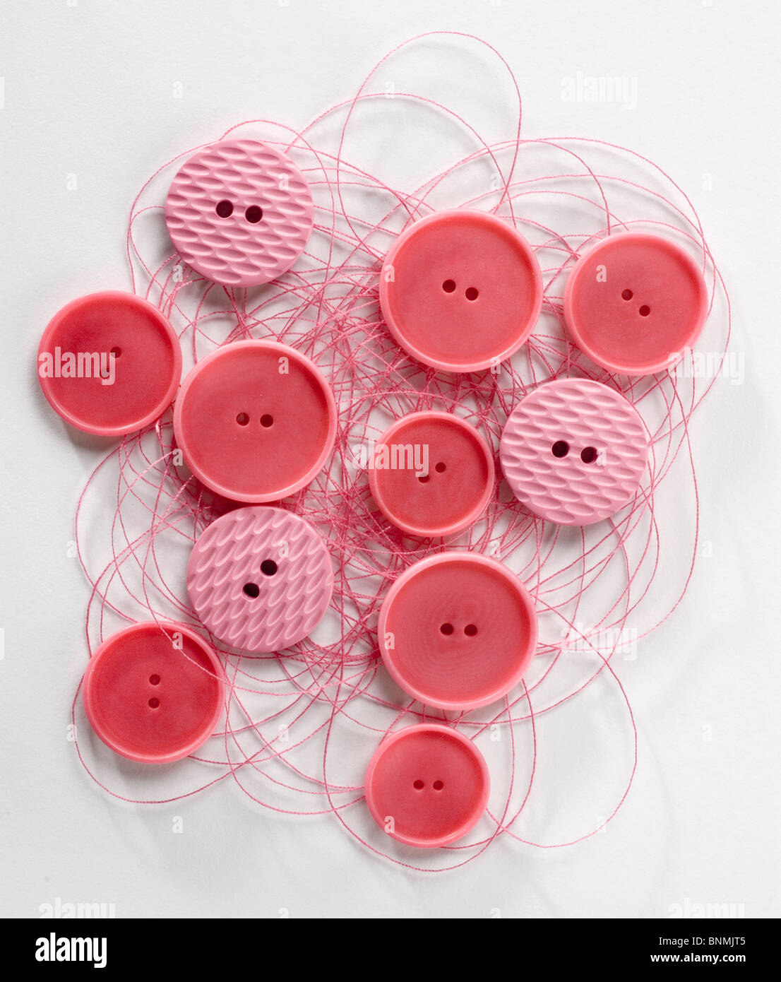 red buttons on red thread cut out Stock Photo - Alamy