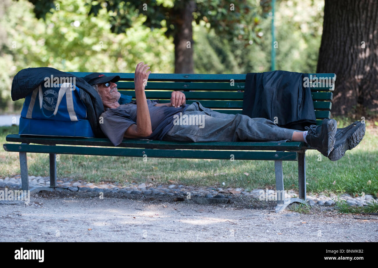Man lying on a bench in a park Stock Photo - Alamy