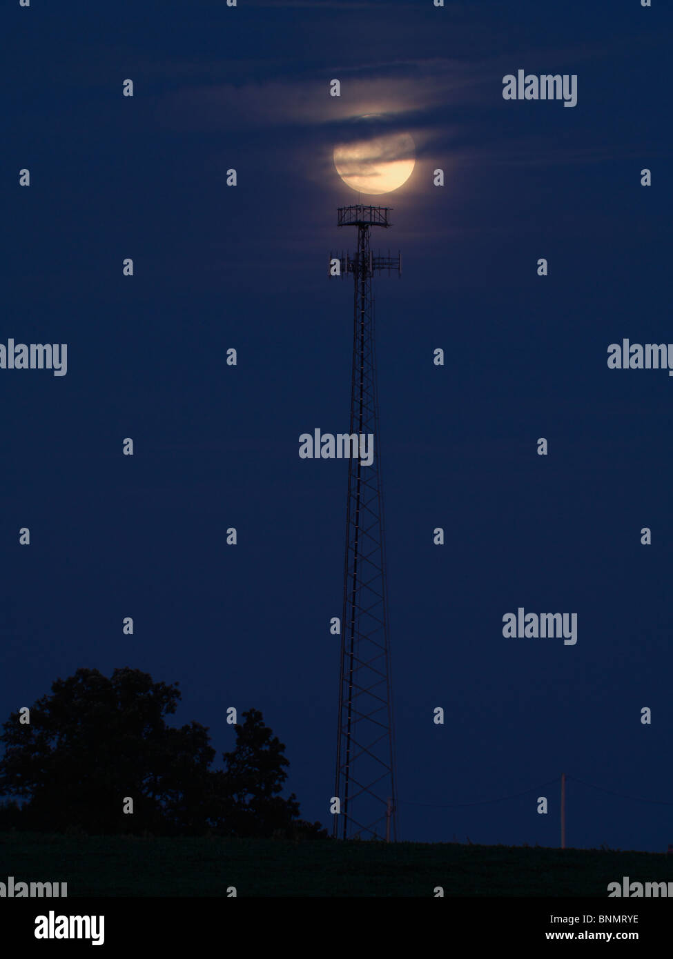 Full Moon behind and silhouetting cell phone tower Stock Photo - Alamy