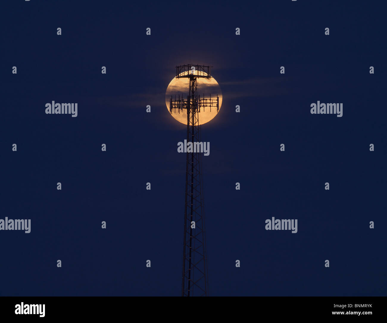 Full Moon behind and silhouetting cell phone tower Stock Photo - Alamy