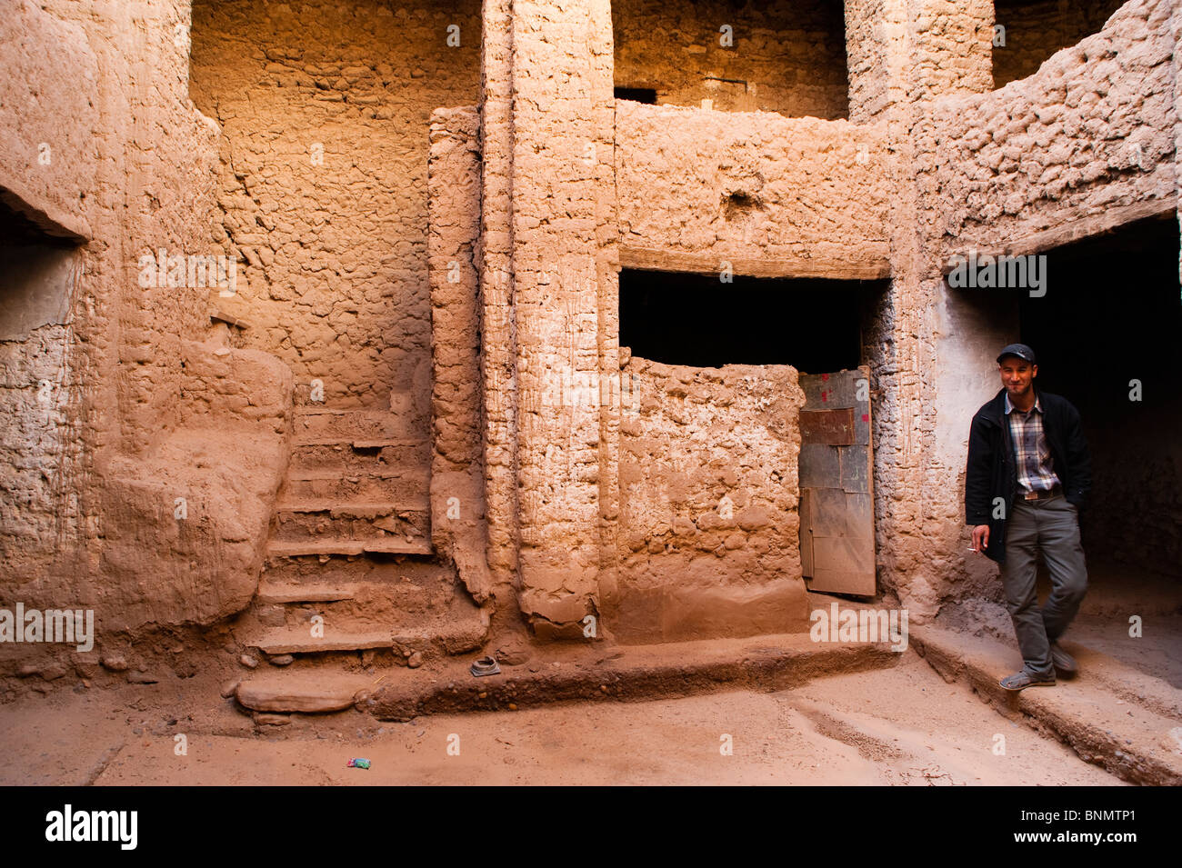 Moroccan labourer in a patio, traditional mud brick building, Figuig ...