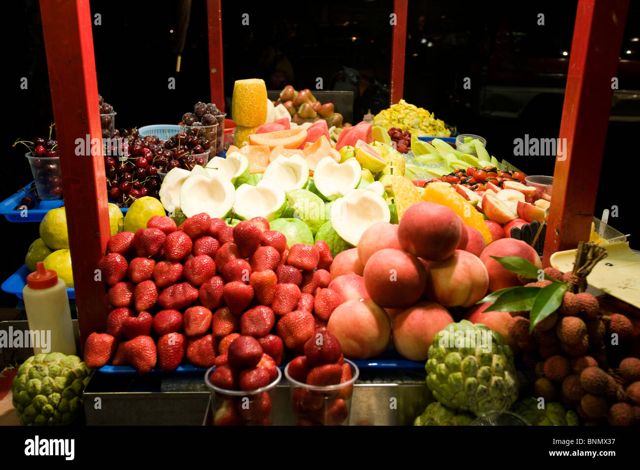 A stand selling a wide variety of fruit and berries displays its wares ...