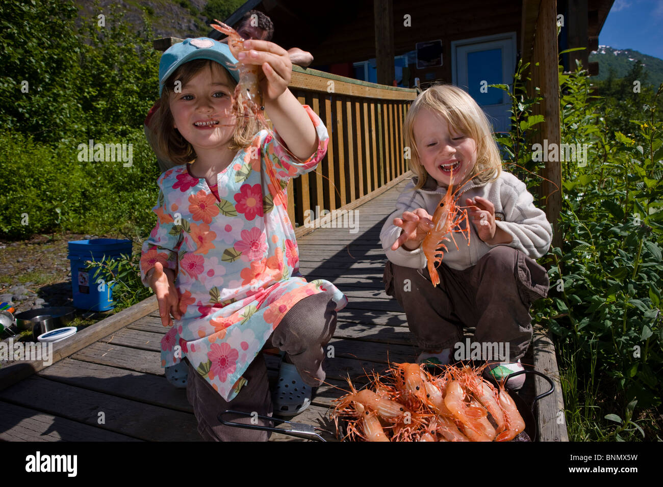 Young girls holding fresh caught shrimp in front of the Kittiwake cabin ...