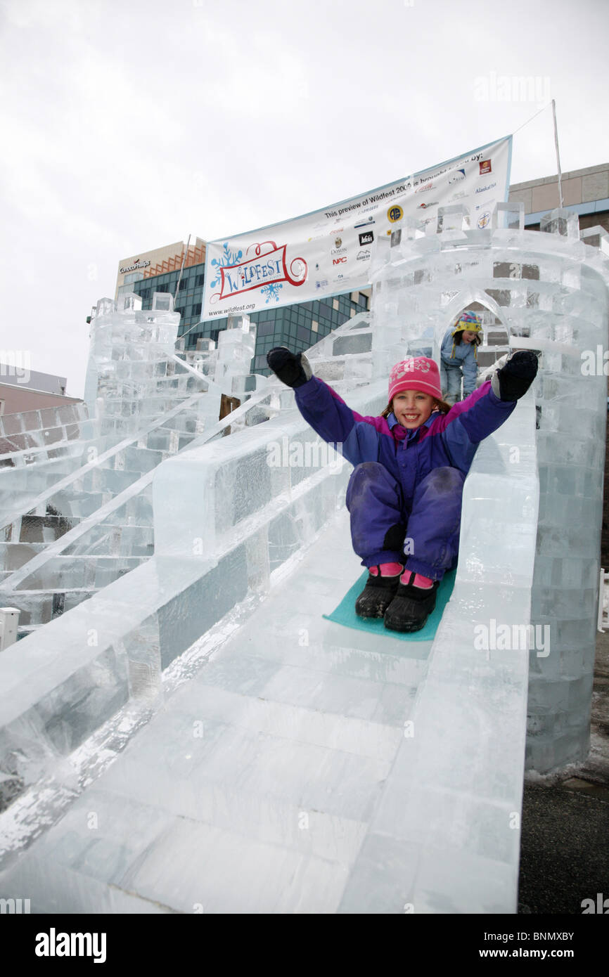 Young girl slides down an ice castle slide in downtown Anchorage ...