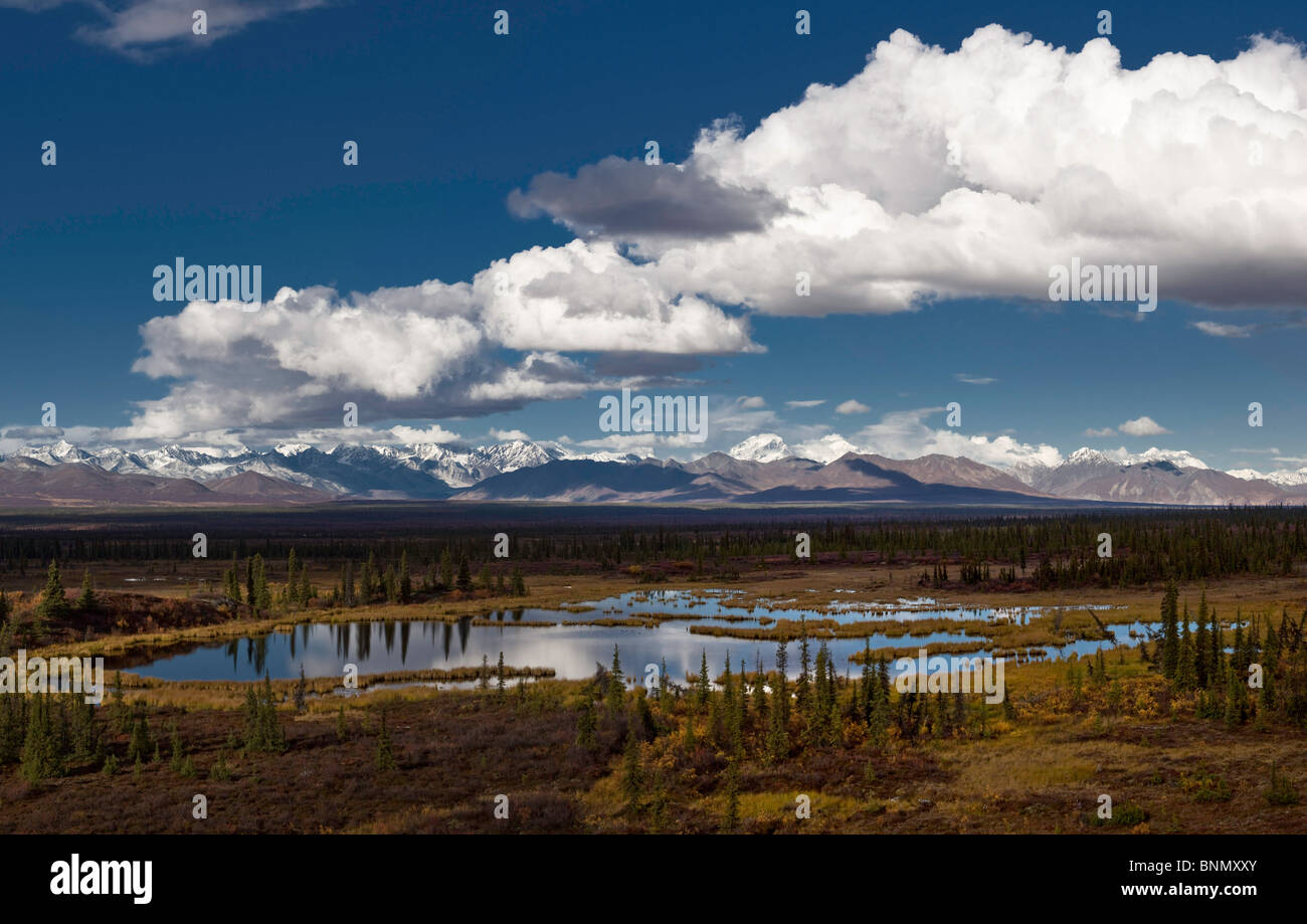 Scenic view of a kettle pond with the Alaska Range in the background ...