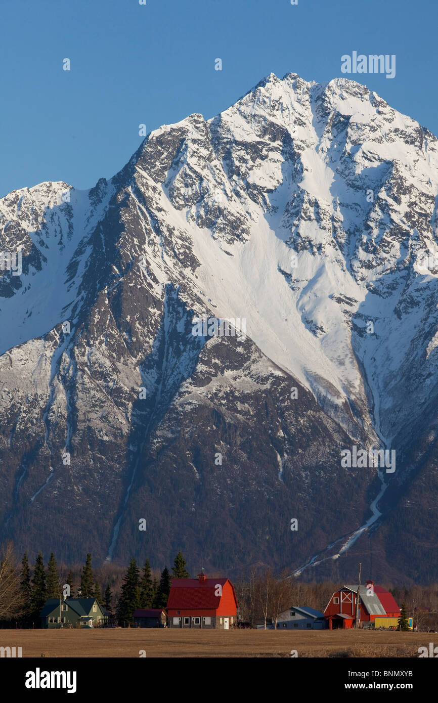 Red barns and homestead in Matanuska Valley with Chugach Mountains in ...