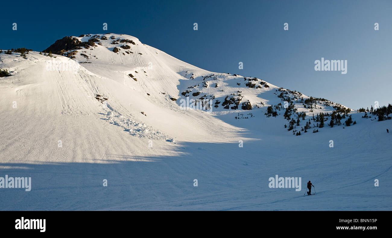 A backcountry skier skinning beneath chunks of a cornice that caused a ...