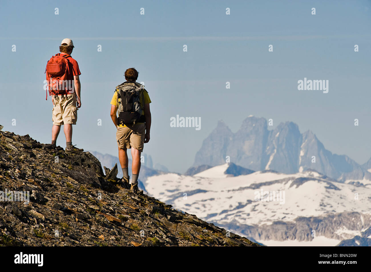 Two hikers take in the view of the Devil's Paw and the Juneau Ice field ...