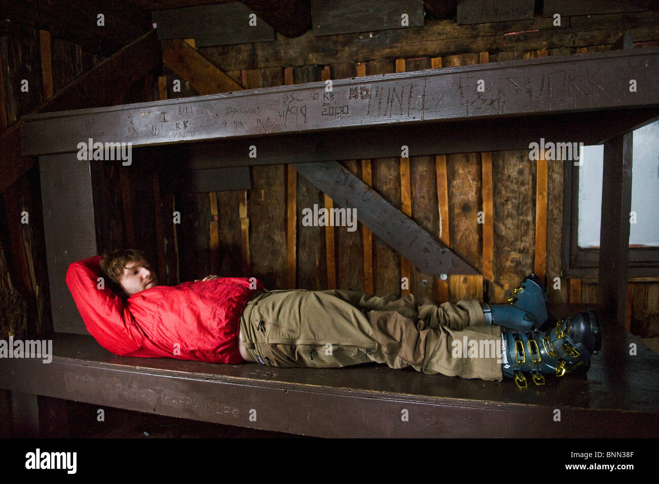 A backcountry skier relaxes on a bunk in the Dan Moller National Forest ...