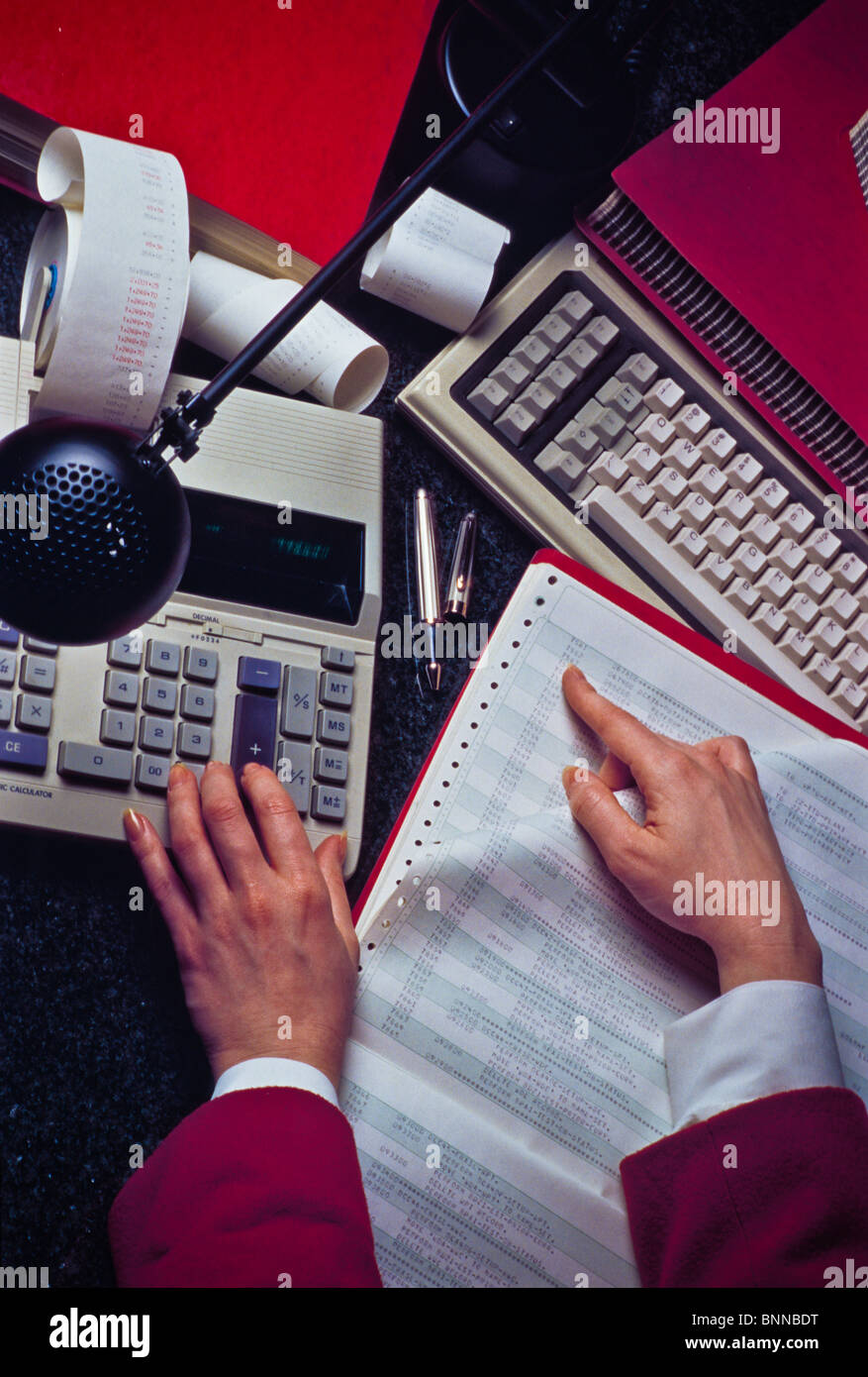Office worker reviews statistics on computer print out forms Stock ...
