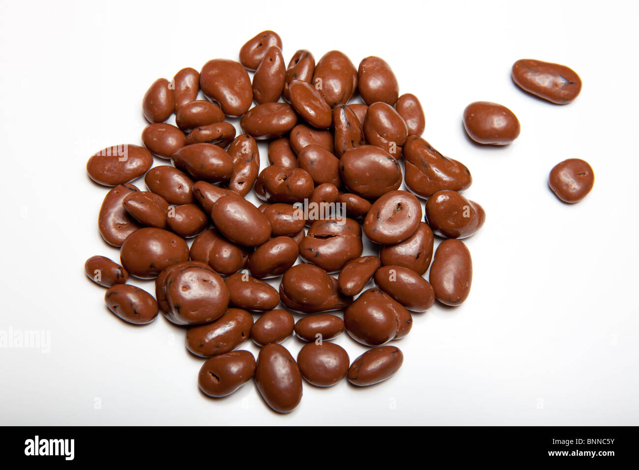 Chocolate covered raisins on a white background Stock Photo - Alamy