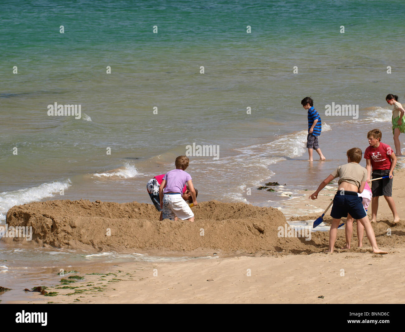 Children digging large hole at the beach, Cornwall, UK Stock Photo - Alamy
