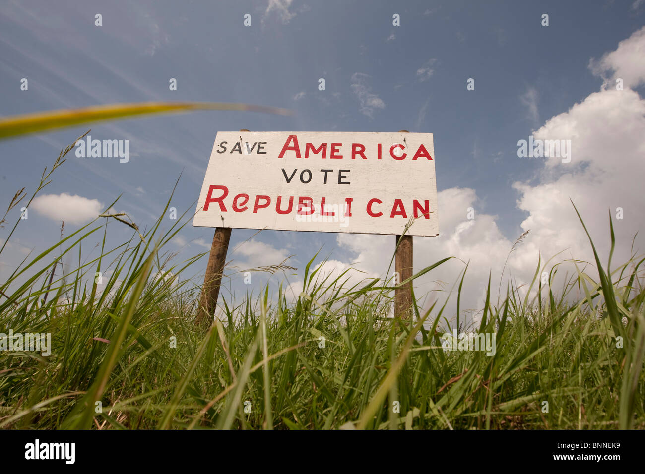 A hand-painted plywood sign urging passers-by to vote Republican stands ...