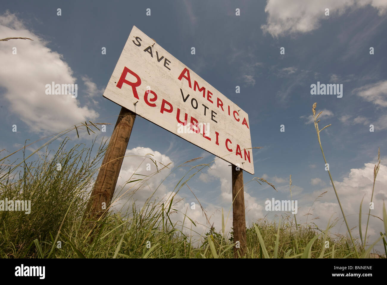 A hand-painted plywood sign urging passers-by to vote Republican stands ...