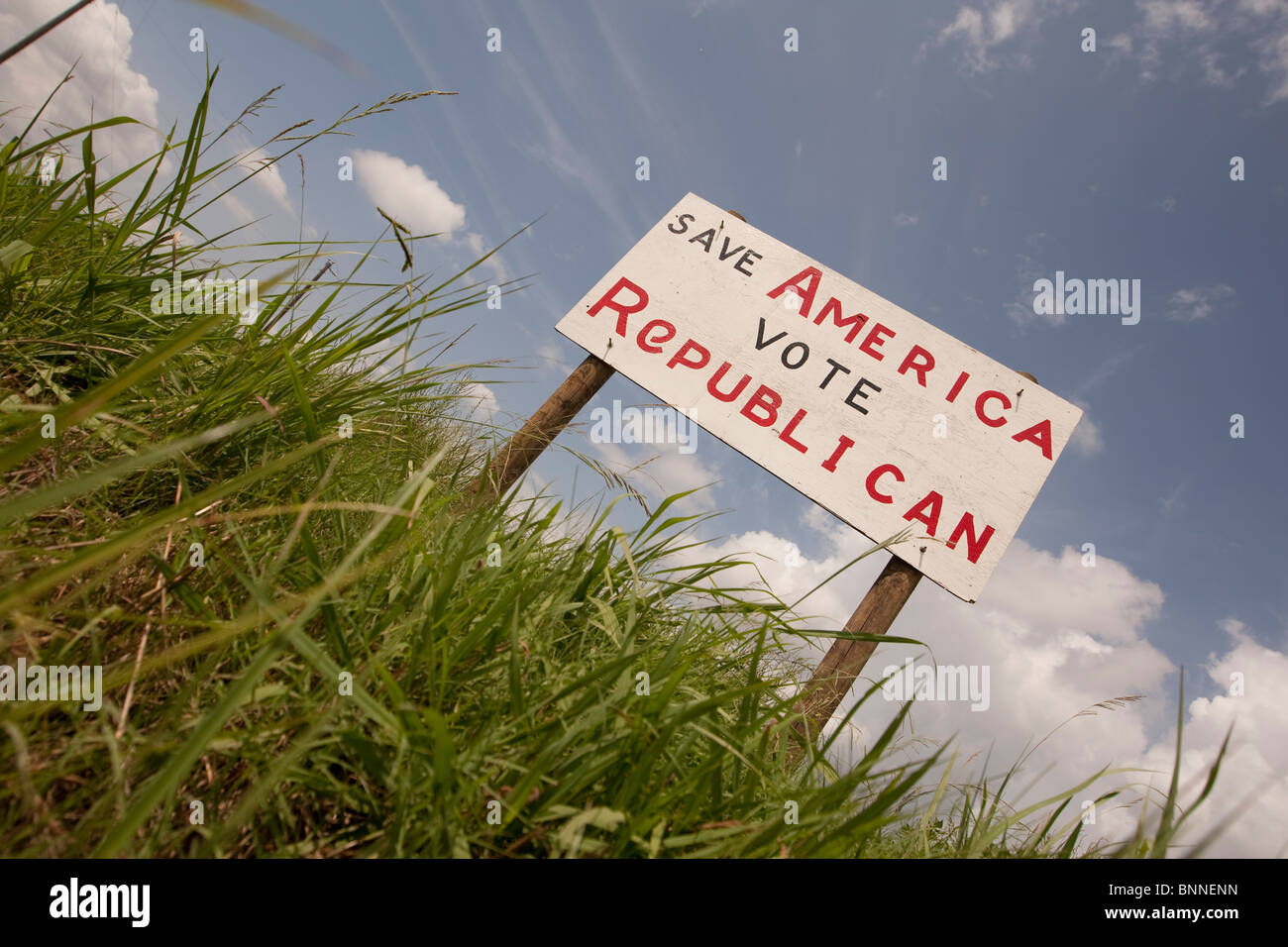A hand-painted plywood sign urging passers-by to vote Republican stands ...