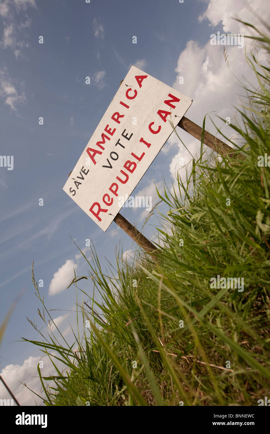 A hand-painted plywood sign urging passers-by to vote Republican stands ...