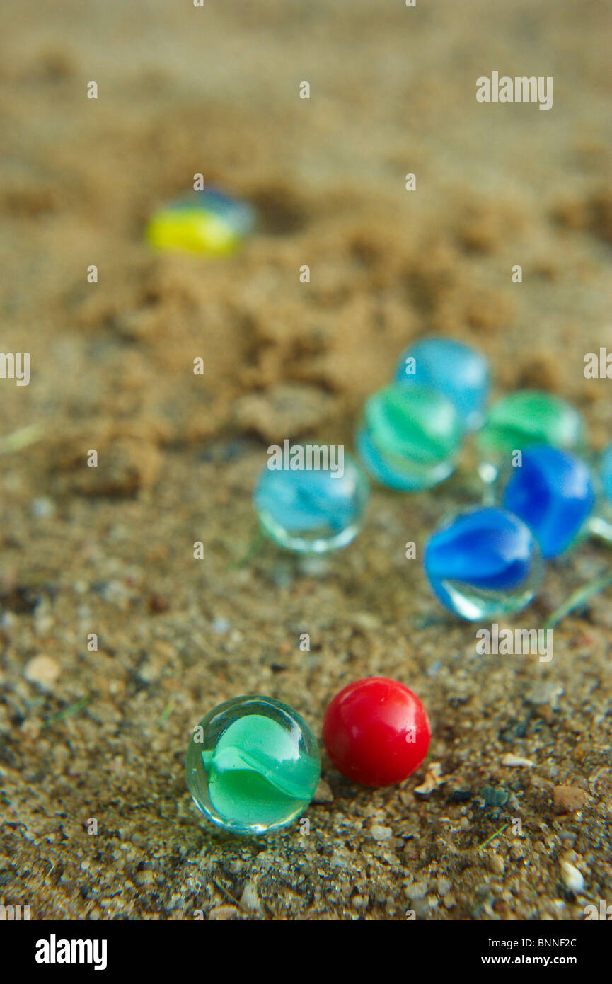 Playing with marbles on sand Stock Photo - Alamy