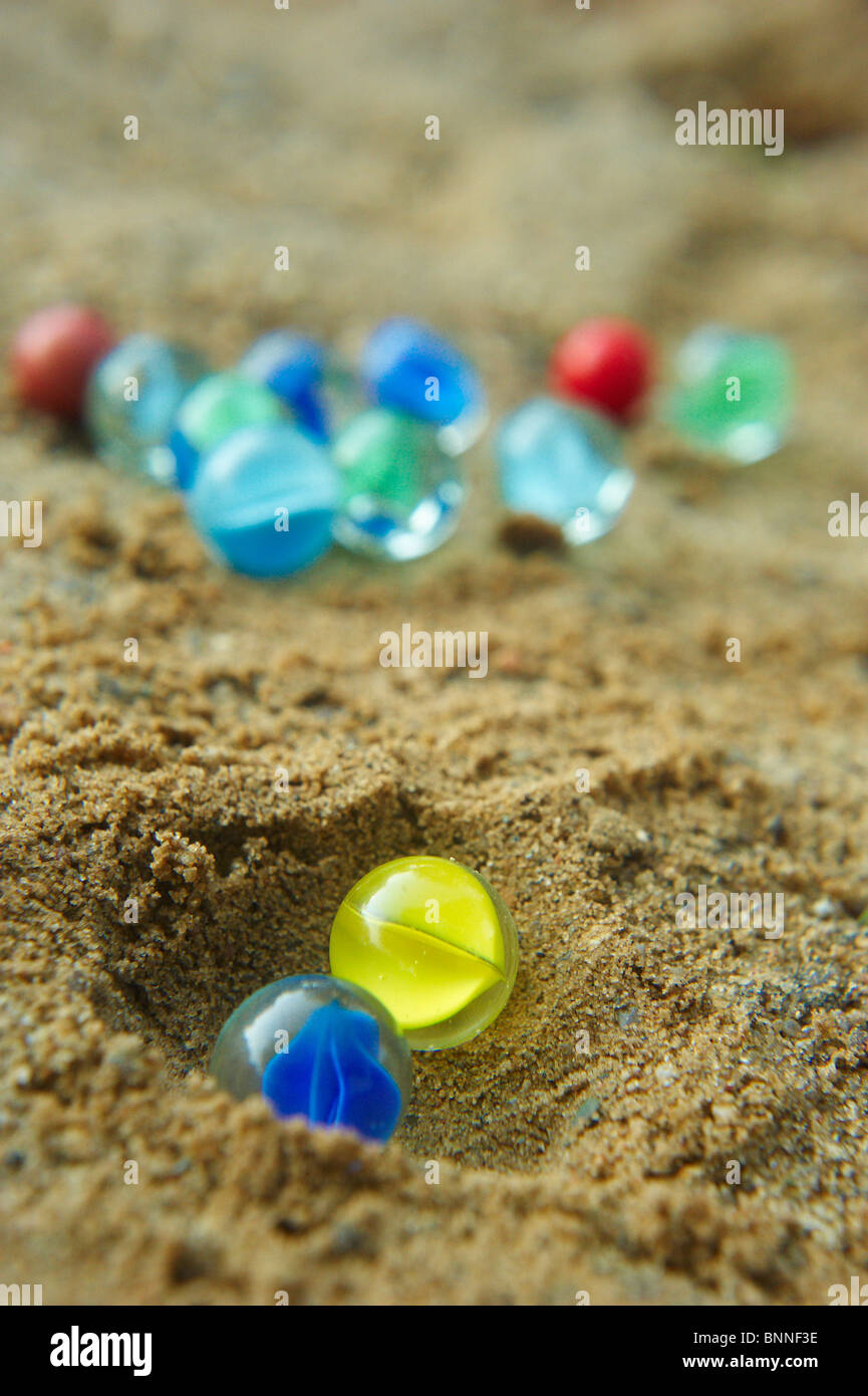 Playing with marbles on sand Stock Photo - Alamy