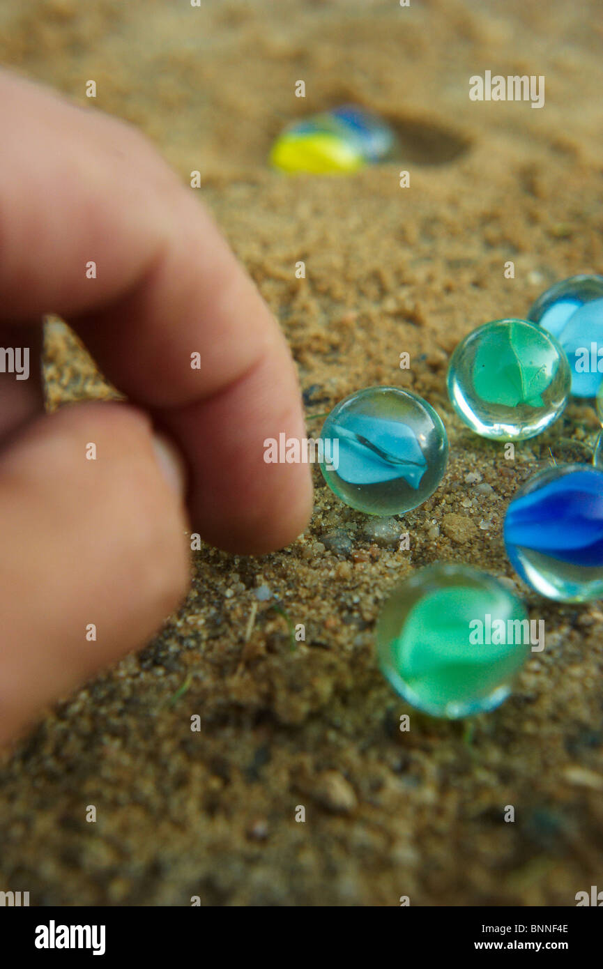Playing with marbles on sand Stock Photo - Alamy
