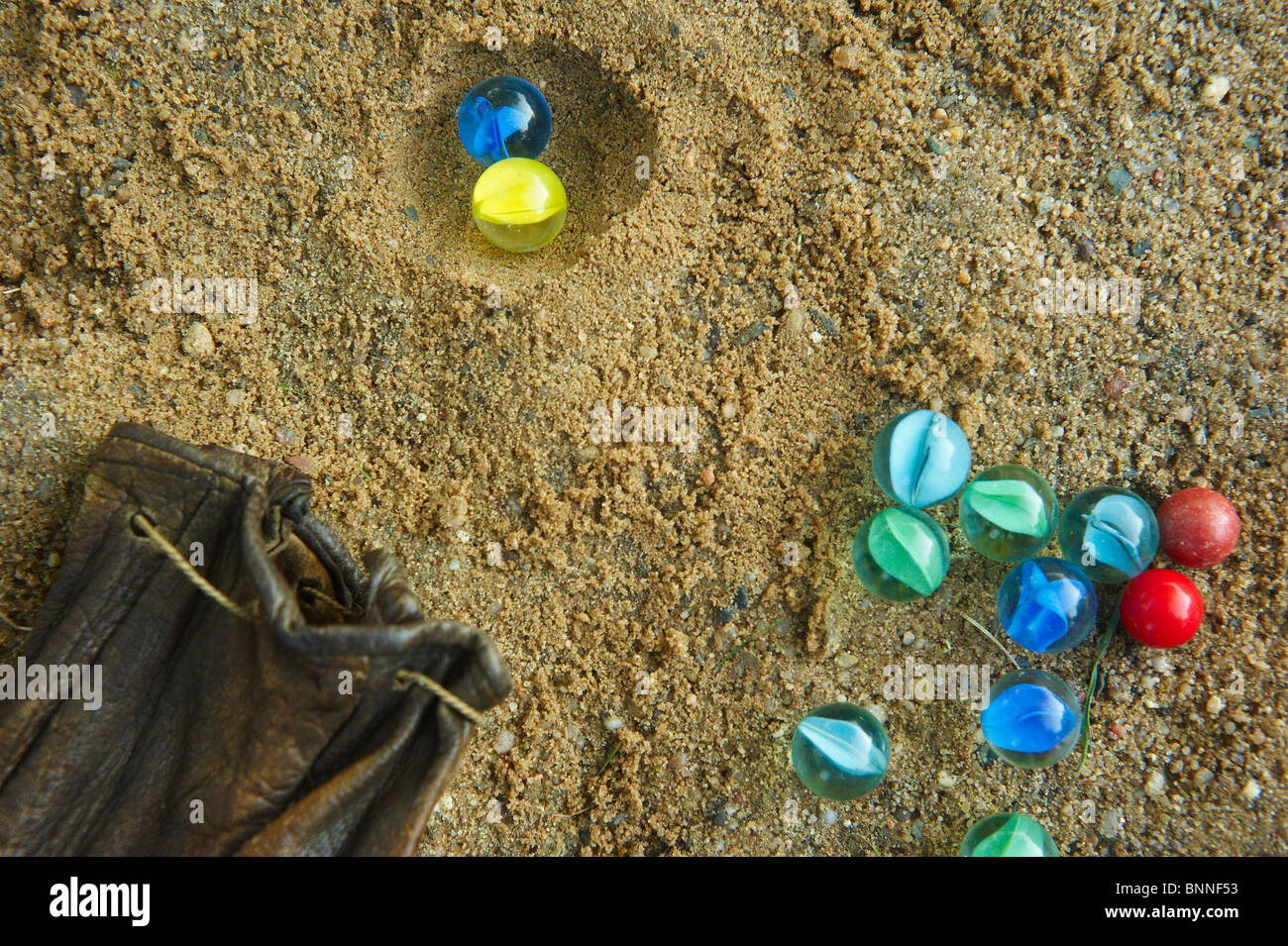 Playing with marbles on sand Stock Photo - Alamy
