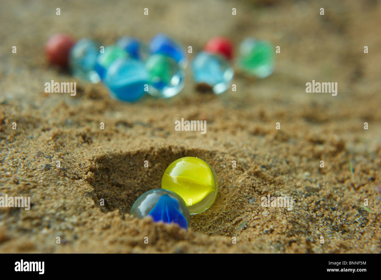 Playing with marbles on sand Stock Photo - Alamy