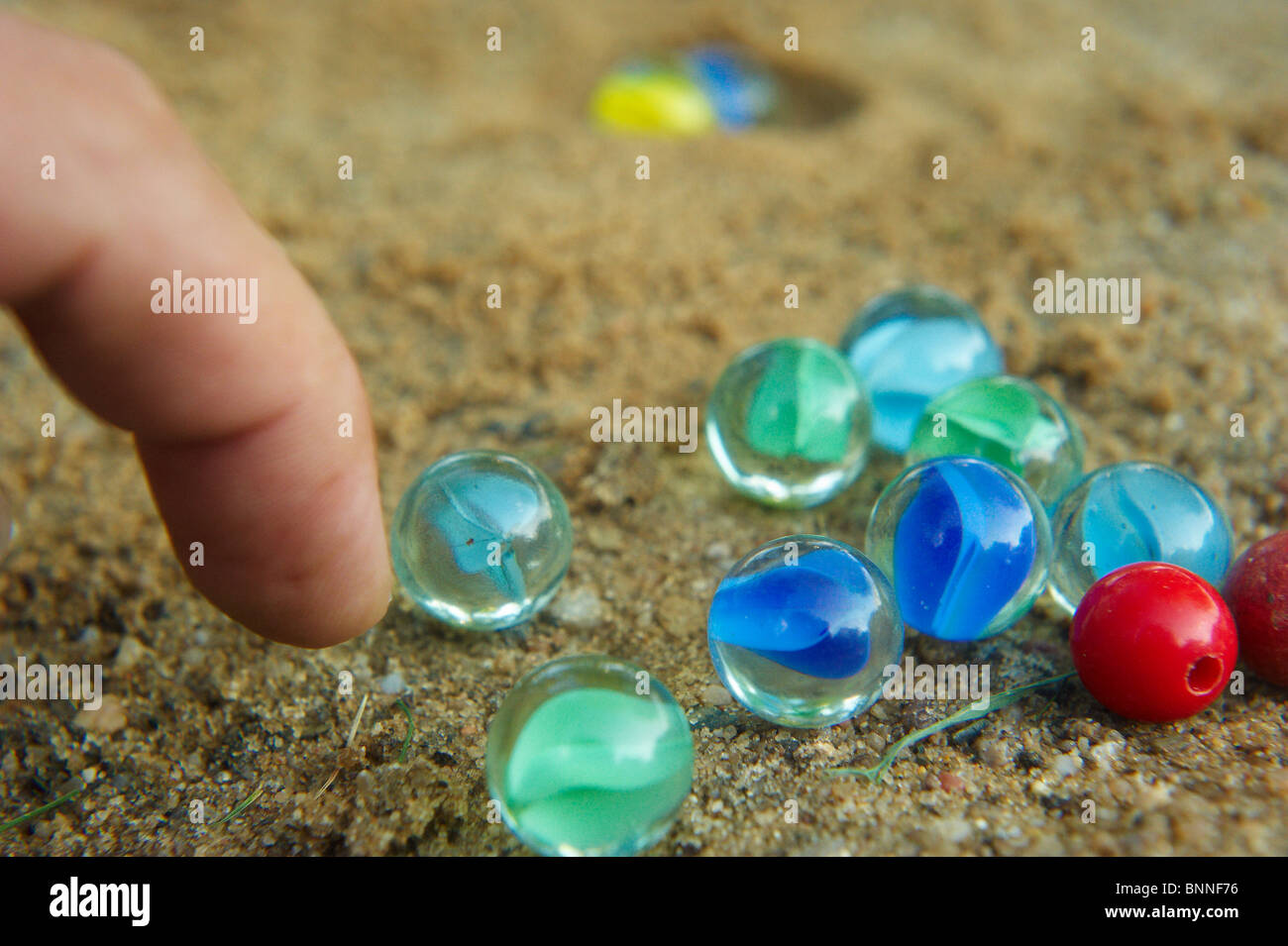 Playing with marbles on sand Stock Photo - Alamy