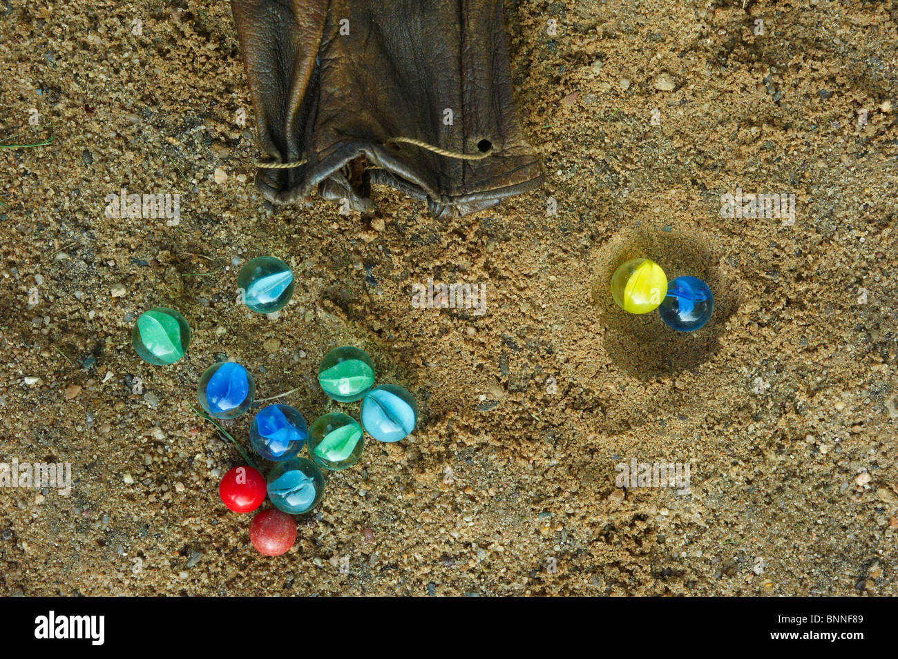Playing with marbles on sand Stock Photo - Alamy