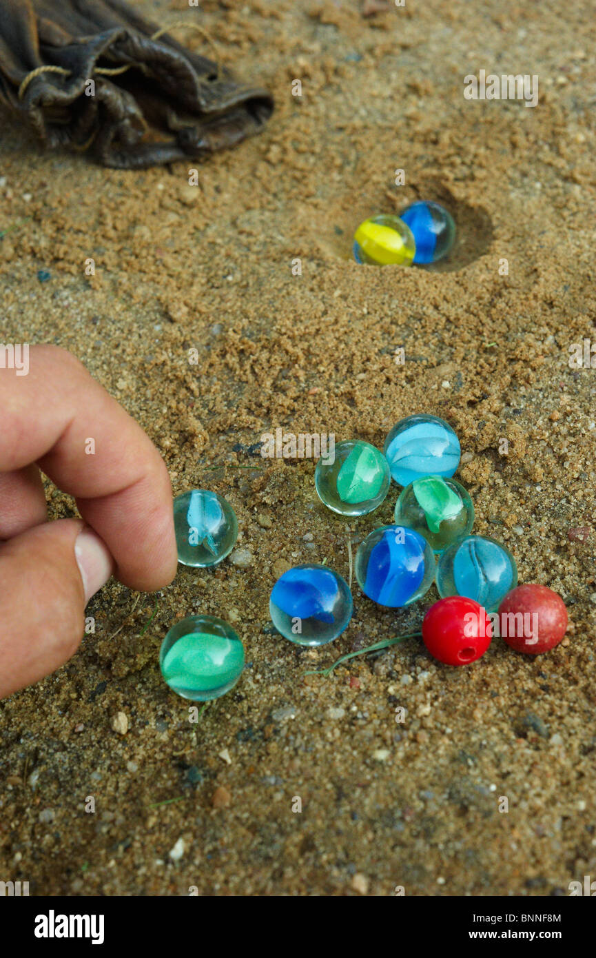 Playing with marbles on sand Stock Photo - Alamy