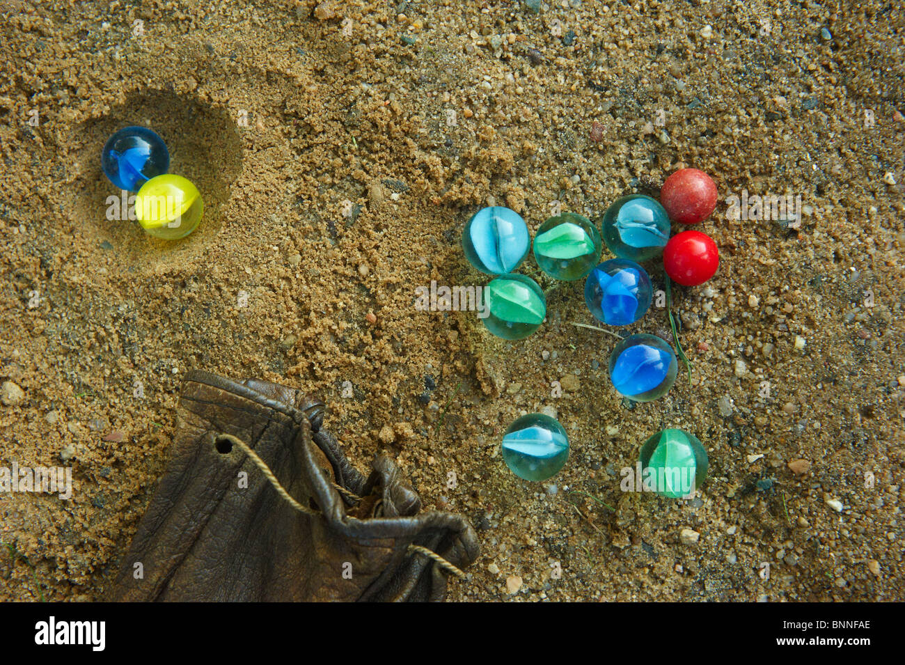 Playing with marbles on sand Stock Photo - Alamy