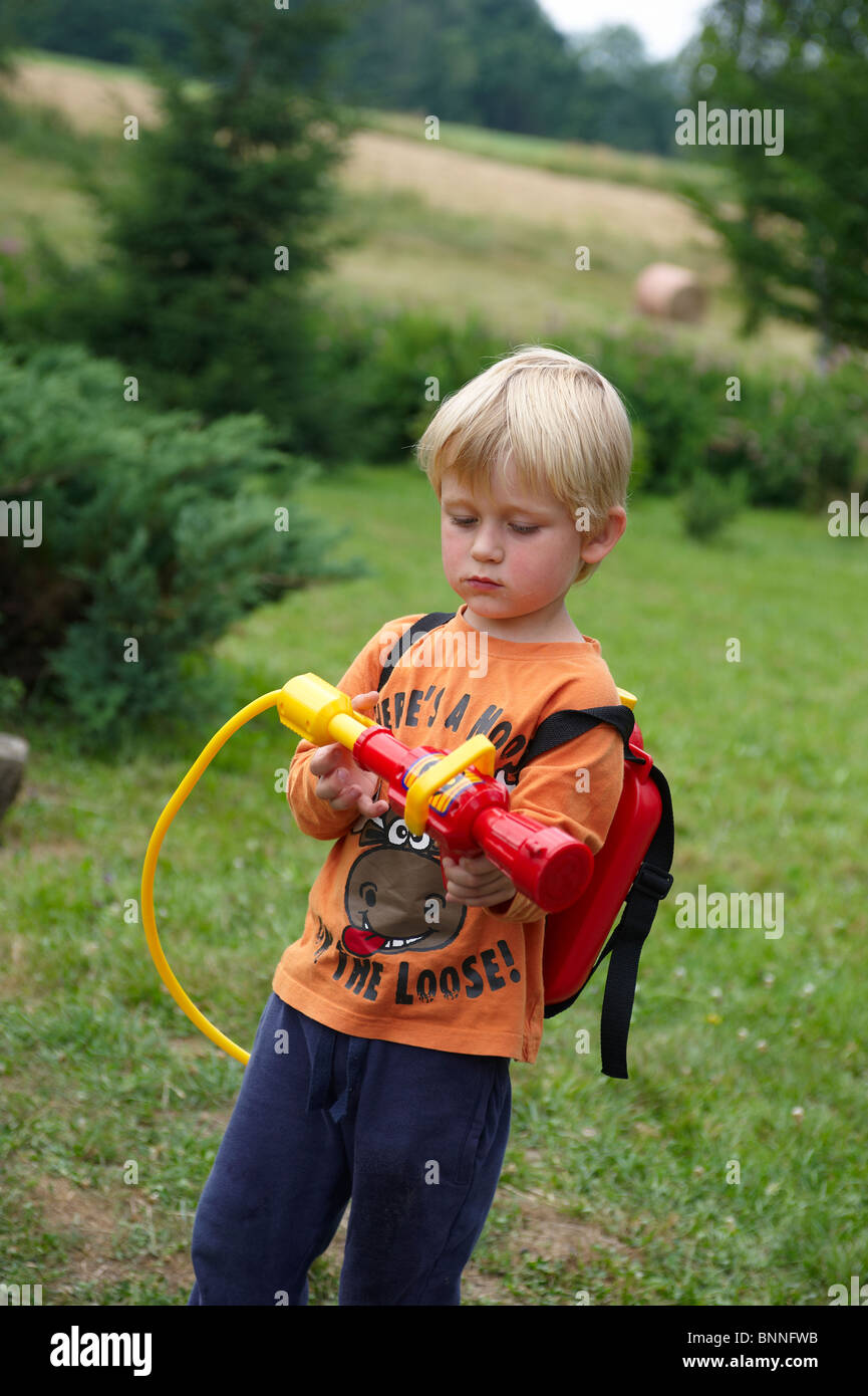 Young child boy playing fire fighter garden Stock Photo - Alamy