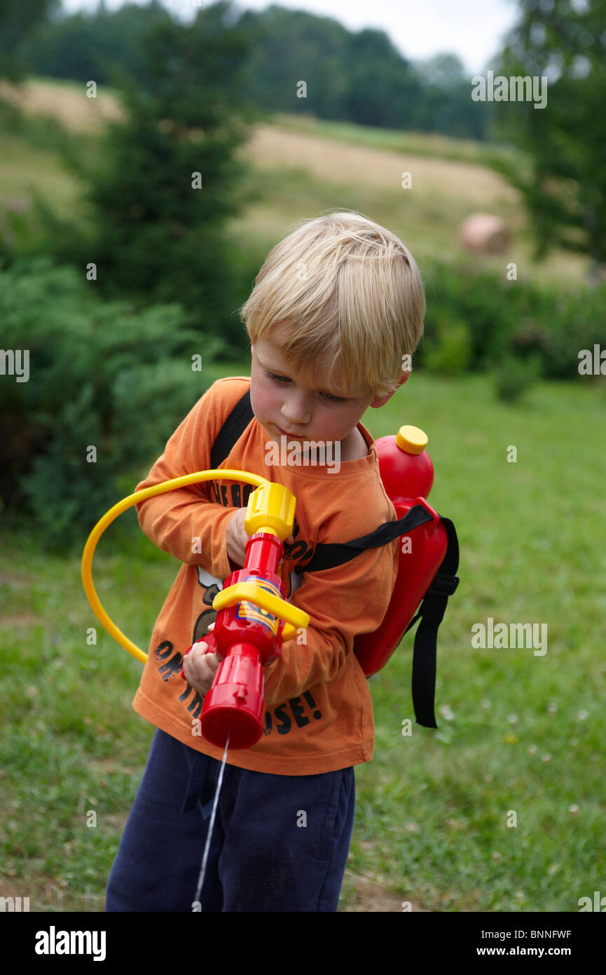 Young child boy playing fire fighter garden Stock Photo - Alamy