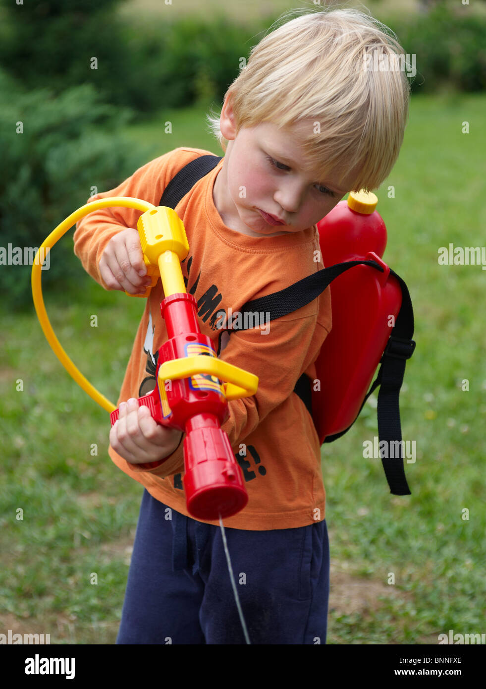 Young child boy playing fire fighter garden Stock Photo - Alamy