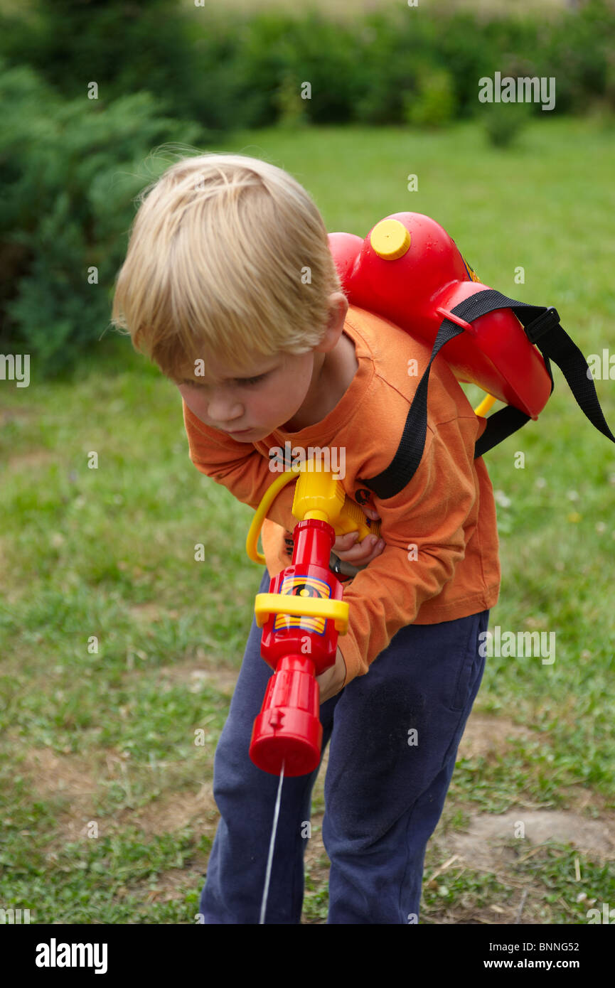 Young child boy playing fire fighter garden Stock Photo - Alamy